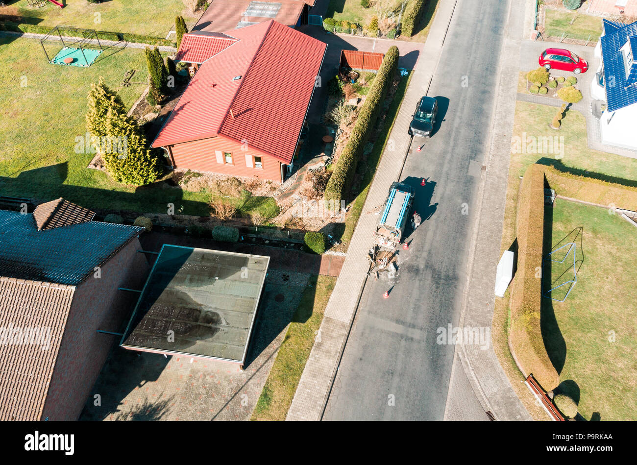 Aerial view of a simple detached house on an asphalted grey village ...
