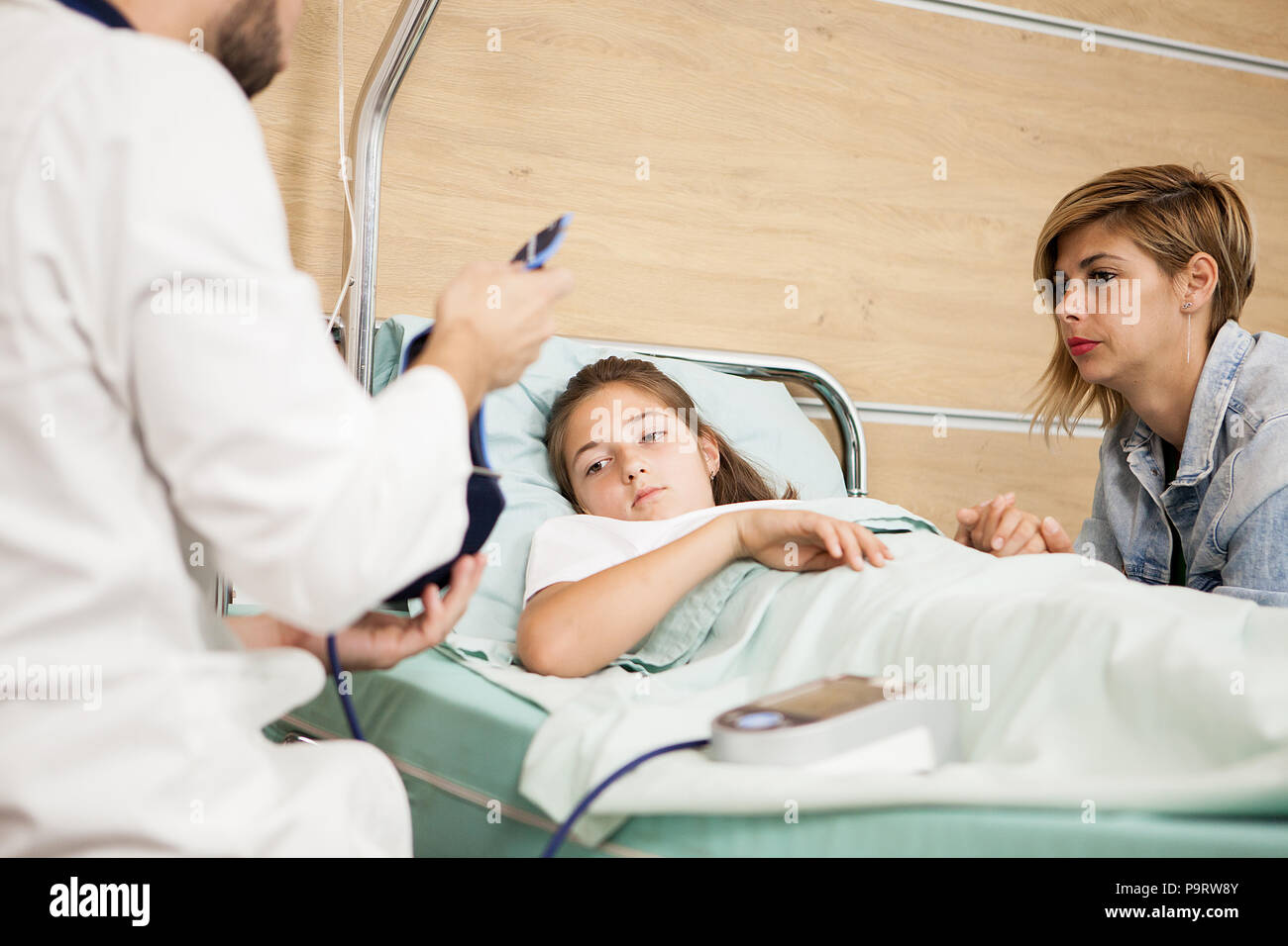 Doctor messuring arterial tension of her patient in hospital room Stock ...