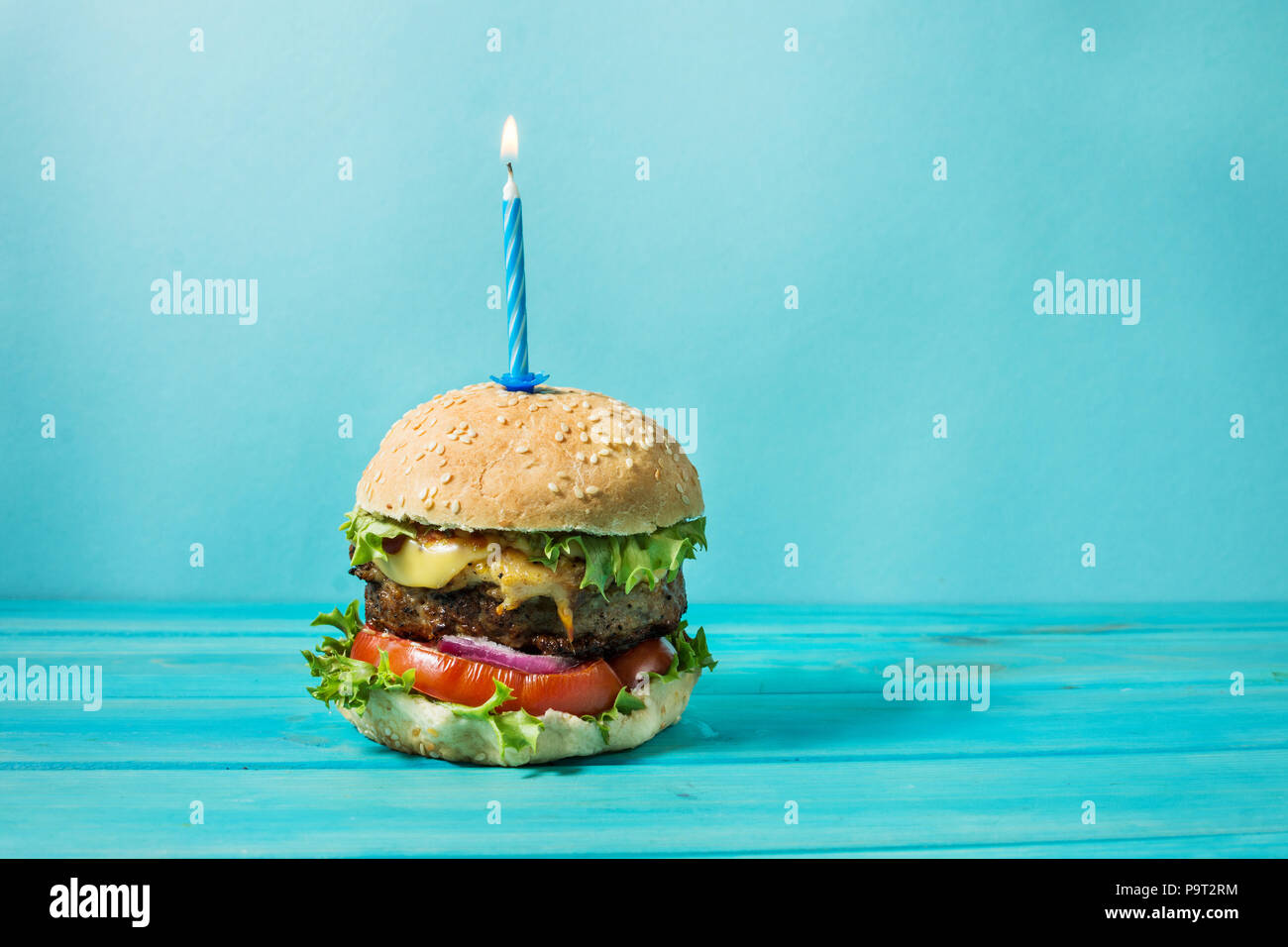 Homemade burger barbeque sandwich with beef and lit candle for birthday ...