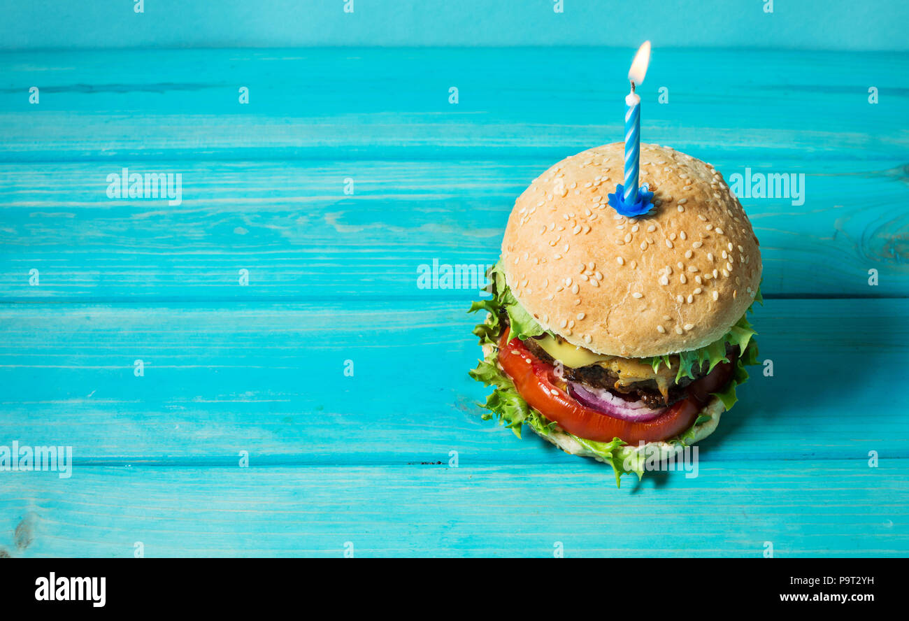 Homemade burger barbeque sandwich with beef and lit candle for birthday ...