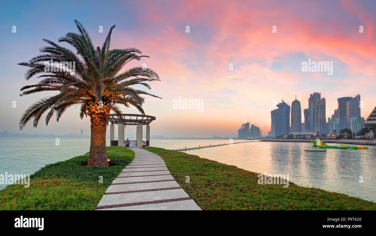 Doha with palm at dramatic sunset, Qatar Stock Photo - Alamy