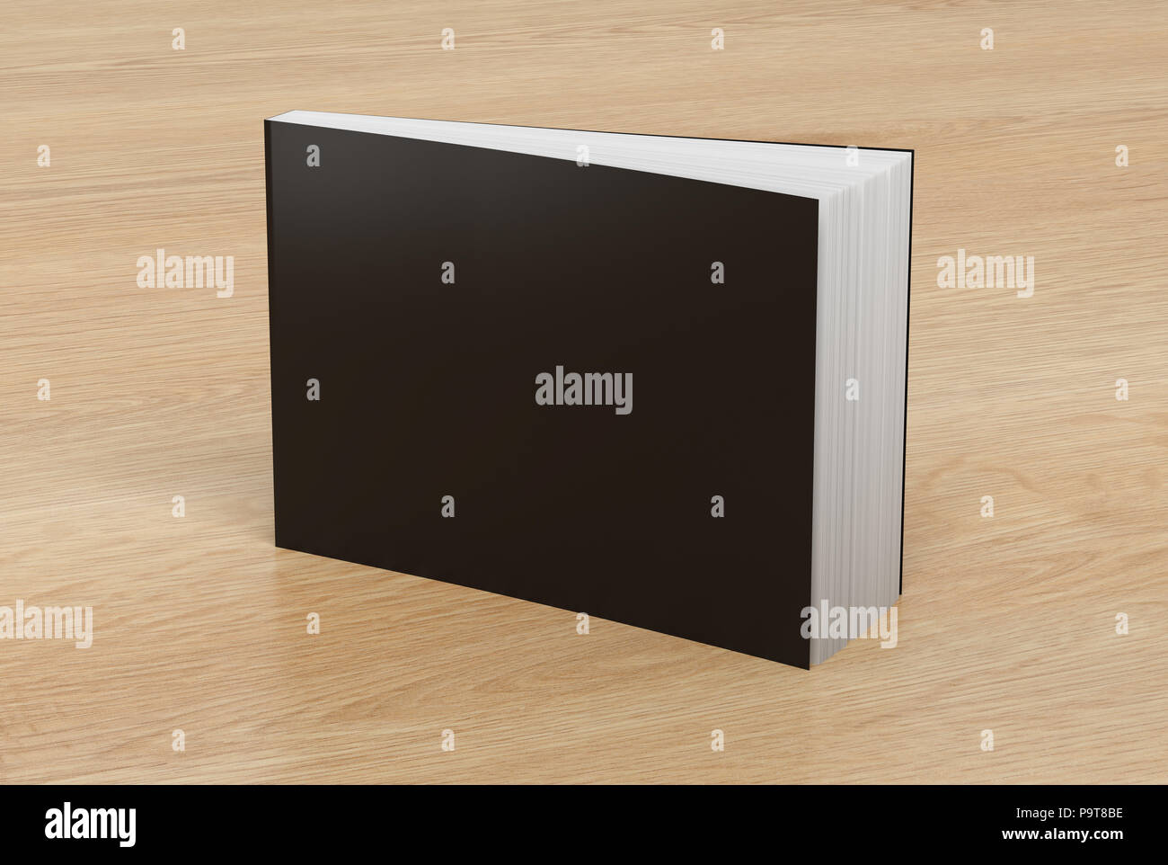 Blank black horizontal soft cover book standing on wooden background ...