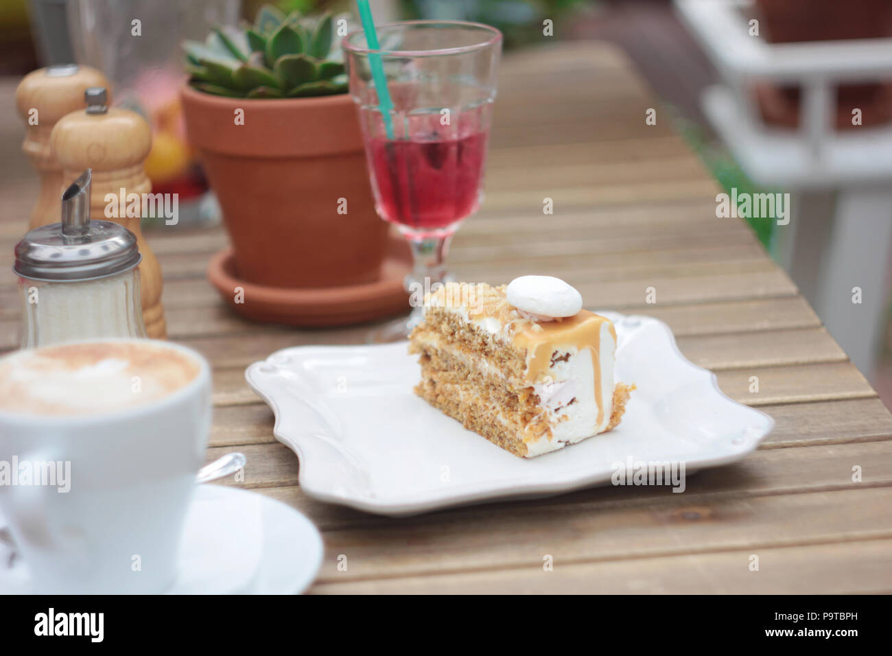 The piece of cake on table of summer terrace in cafe, picnic, set table ...