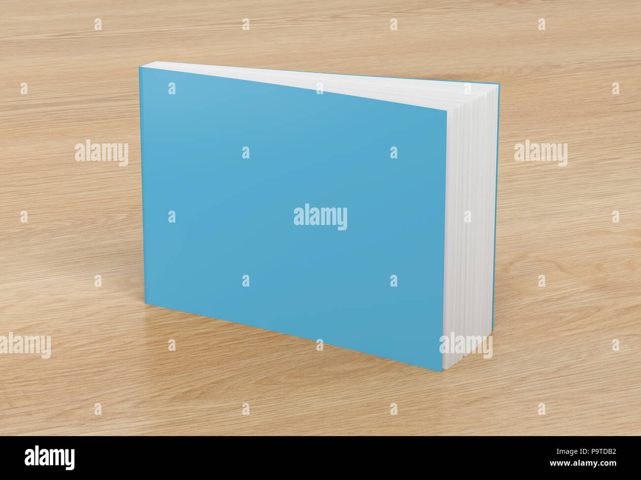 Blank cyan horizontal soft cover book standing on wooden background ...
