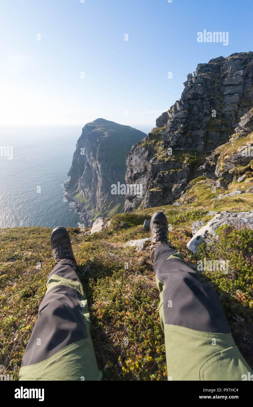 Hiker in the summit of mountain Ryten in the Lofoten Islands, Norway ...