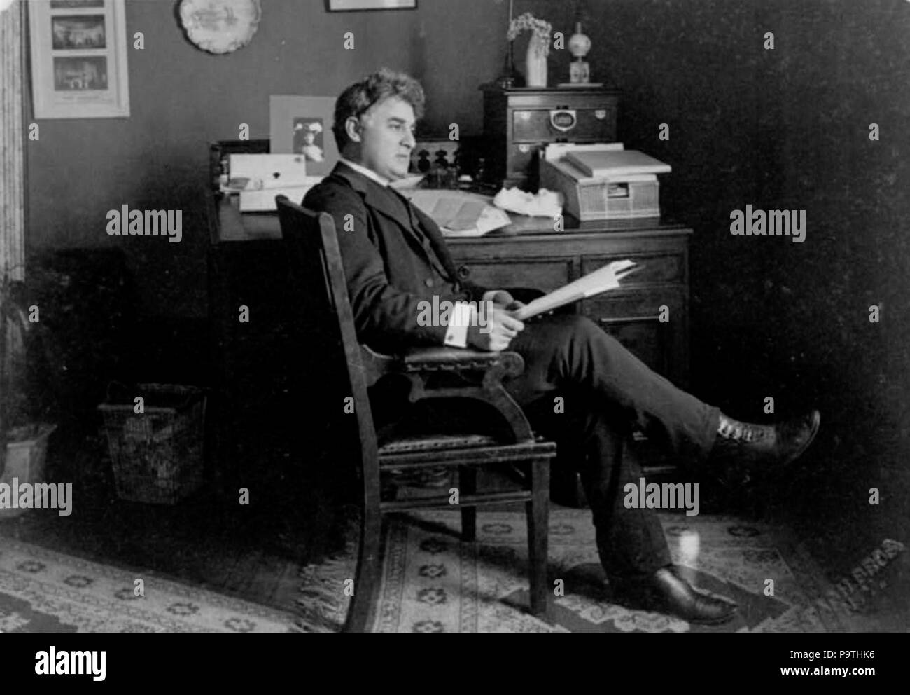 . English: David Belasco, full-length portrait, seated at desk, facing ...