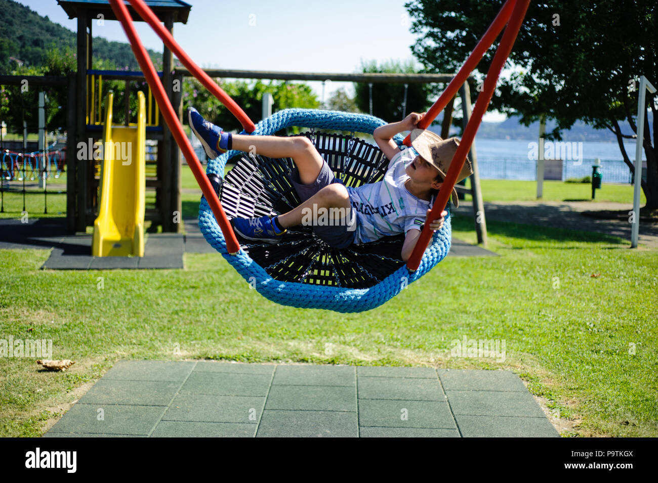 child plays on the swing in the park Stock Photo - Alamy