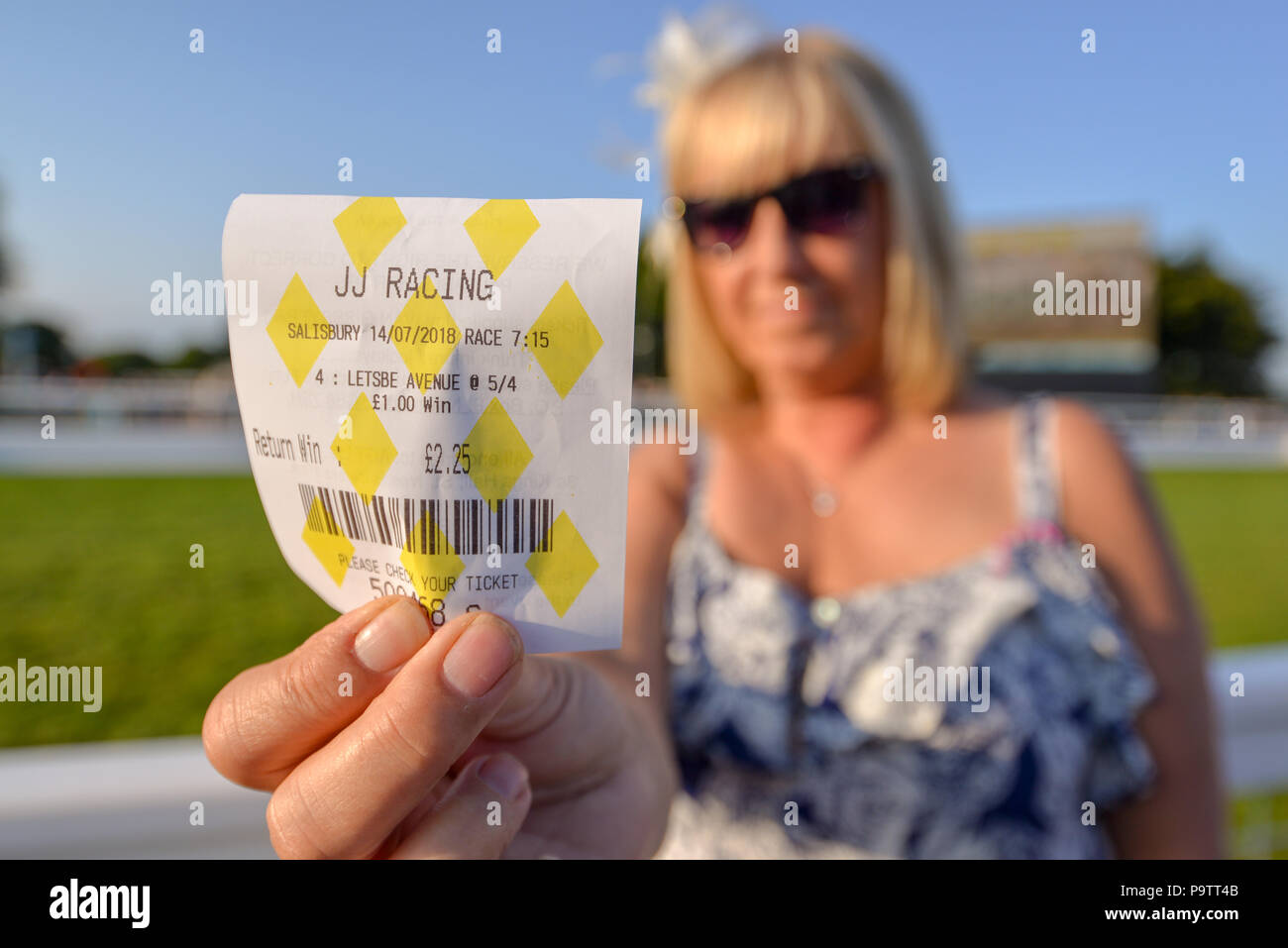 Woman holding a winning bookmakers ticket at a horse racing meeting in ...