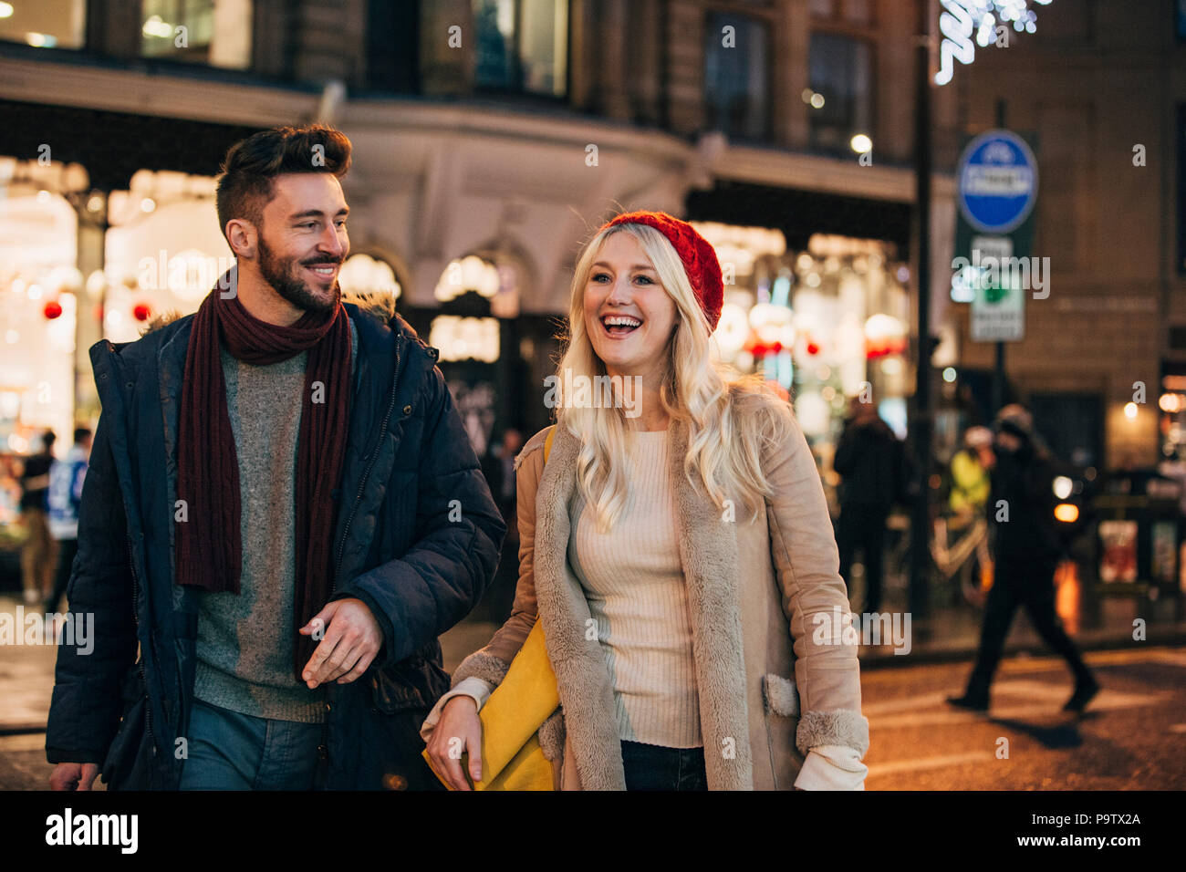 Front view of a couple walking together while laughing and smiling ...