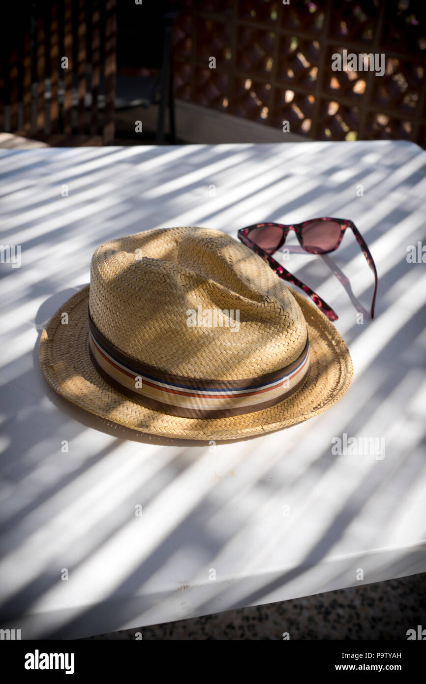 still life of well used man’s straw hat with stripey band next to ...