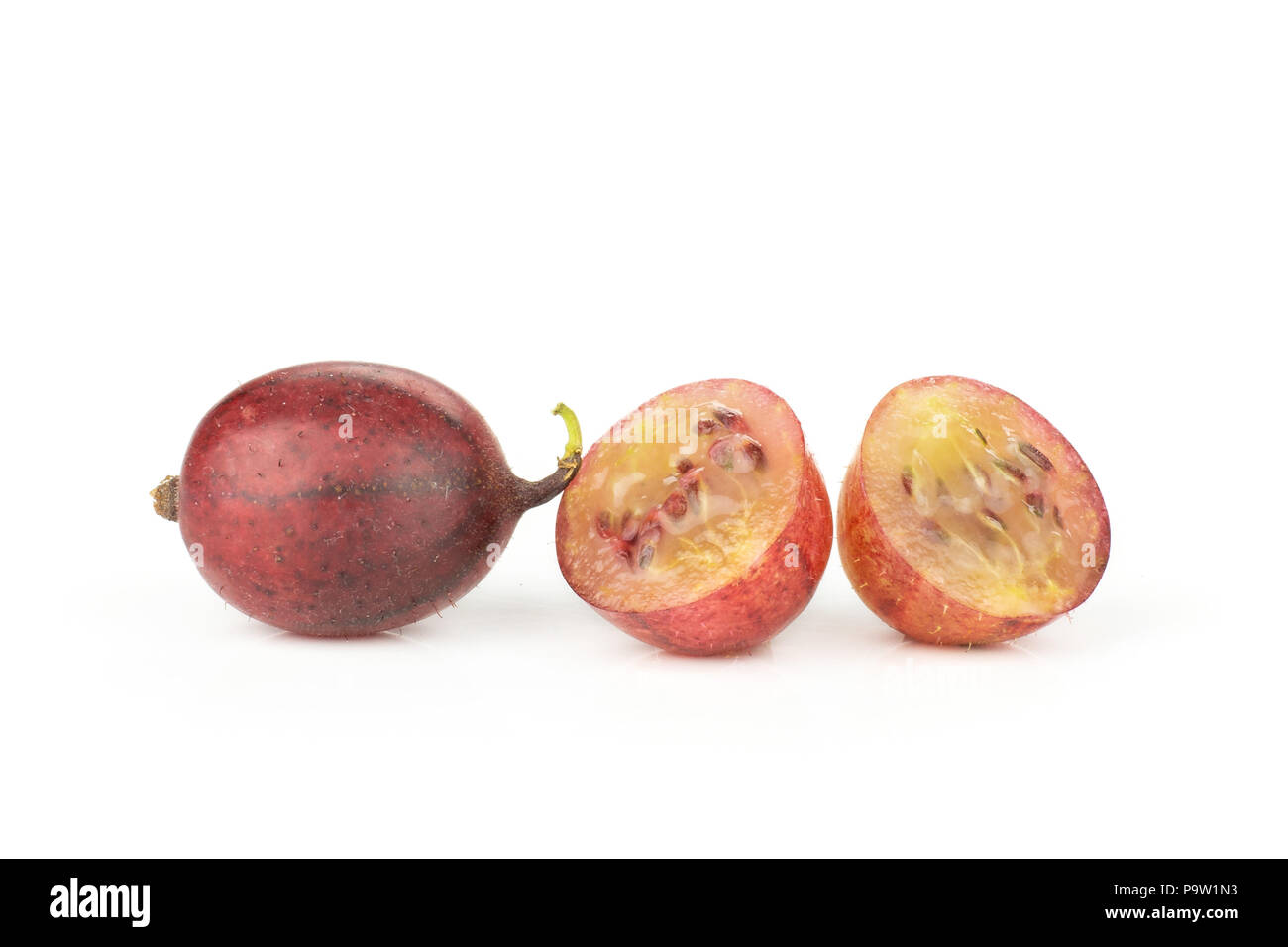 Group of one whole two halves of fresh red gooseberry hinnomaki variety ...