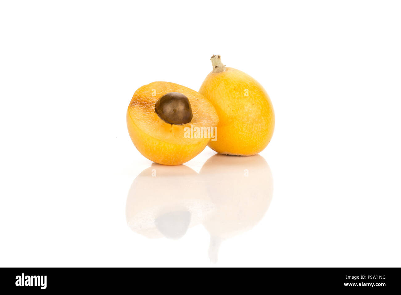 Fresh orange Japanese loquat and one sliced half with a seed inside ...