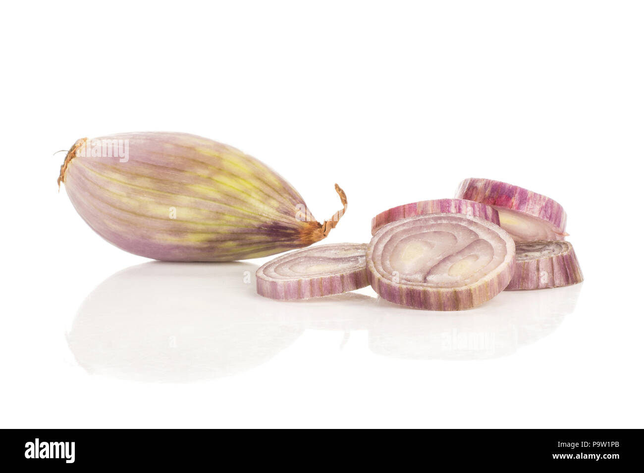 One peeled shallot with ring slices stack isolated on white background ...