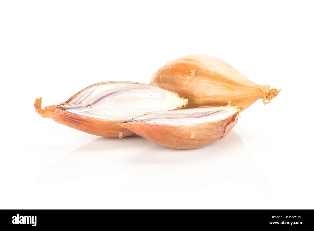 Two golden shallots one cut in halves isolated on white background ...