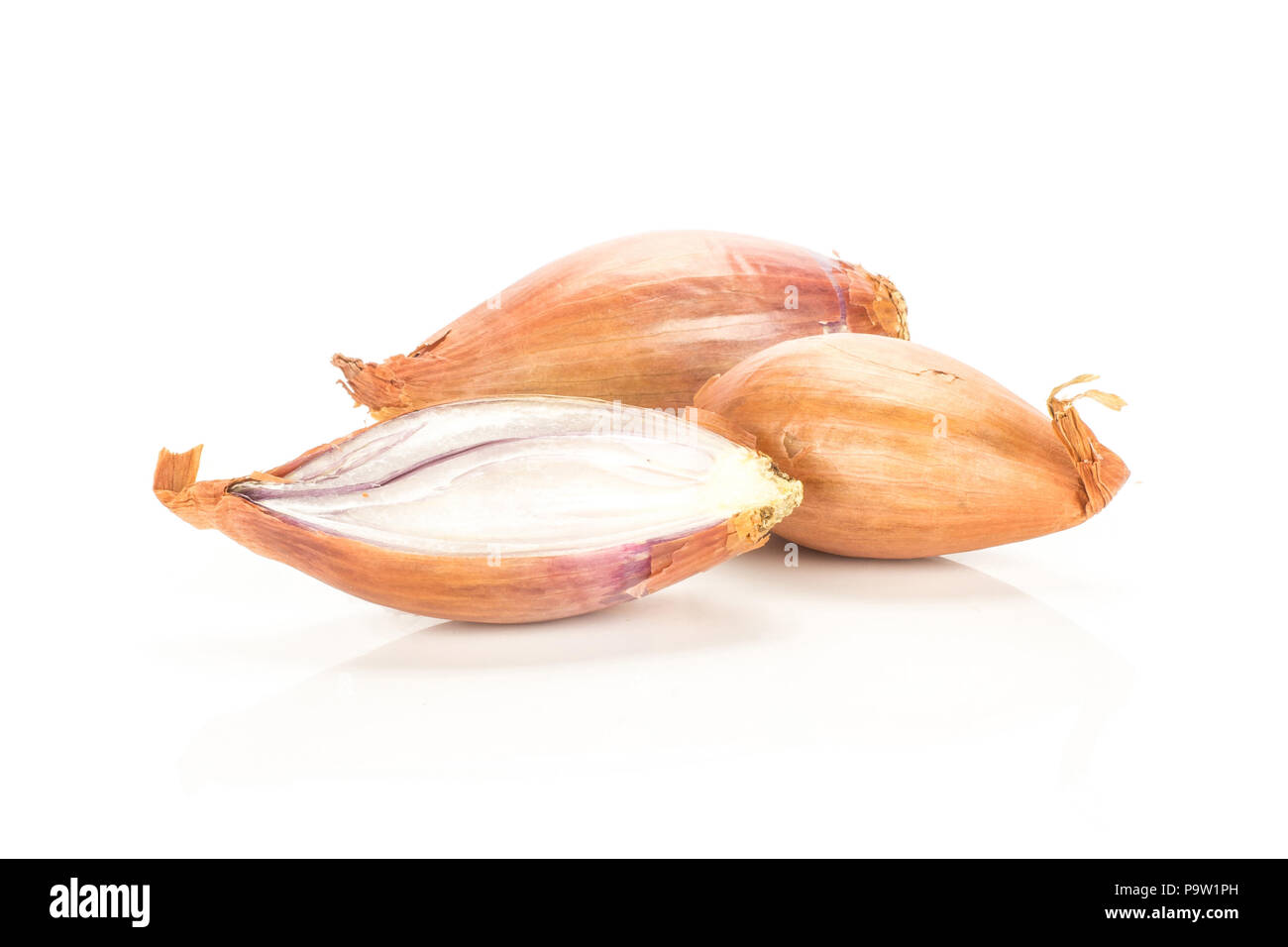 Two golden shallots with one sliced half isolated on white background ...