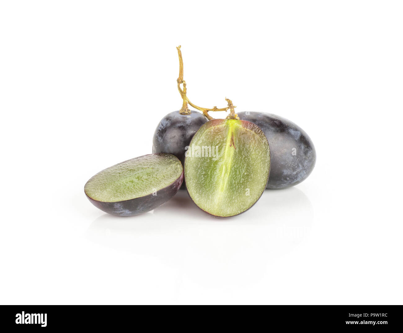 Black grapes (autumn royal variety) two berries and two sliced halves ...