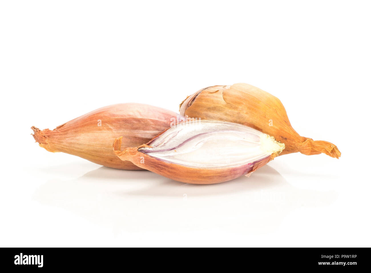 Two golden shallots with one section half isolated on white background ...