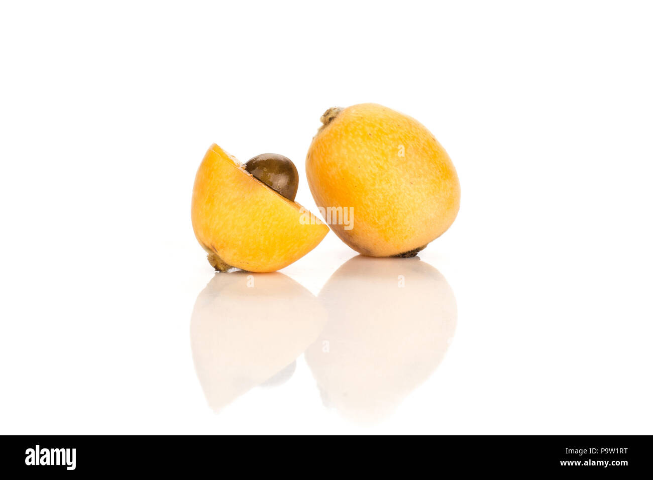 One fresh orange Japanese loquat one half with a seed isolated on white ...
