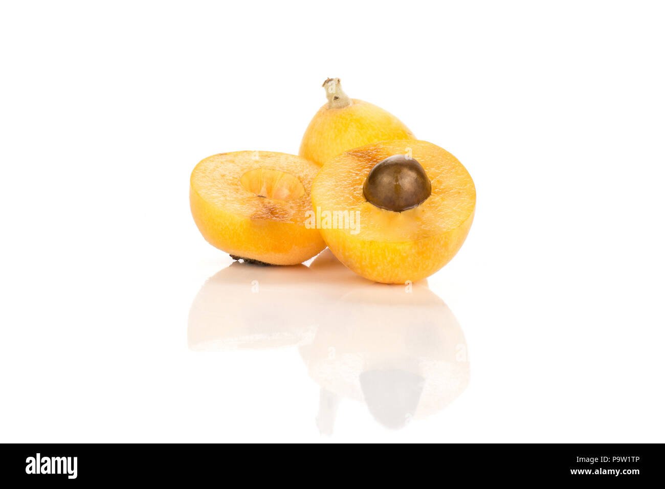 One fresh orange Japanese loquat and two halves isolated on white ...