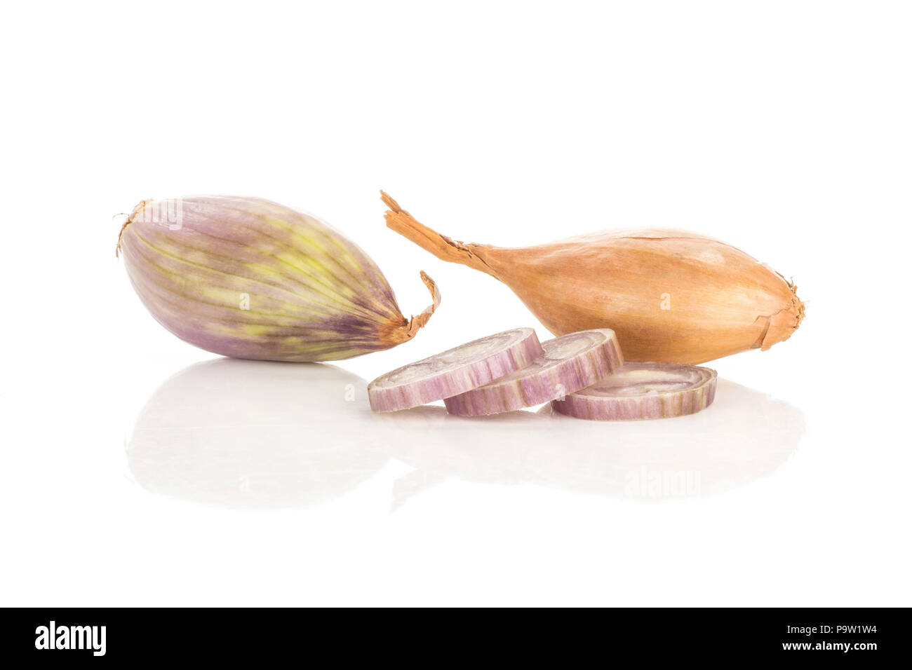 Two shallots one in golden husk and one peeled with three ring slices ...
