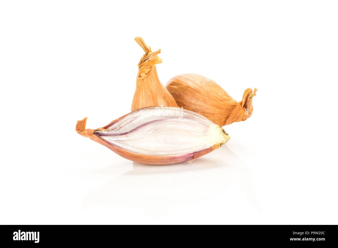 Two unpeeled shallots with one sliced half isolated on white background ...