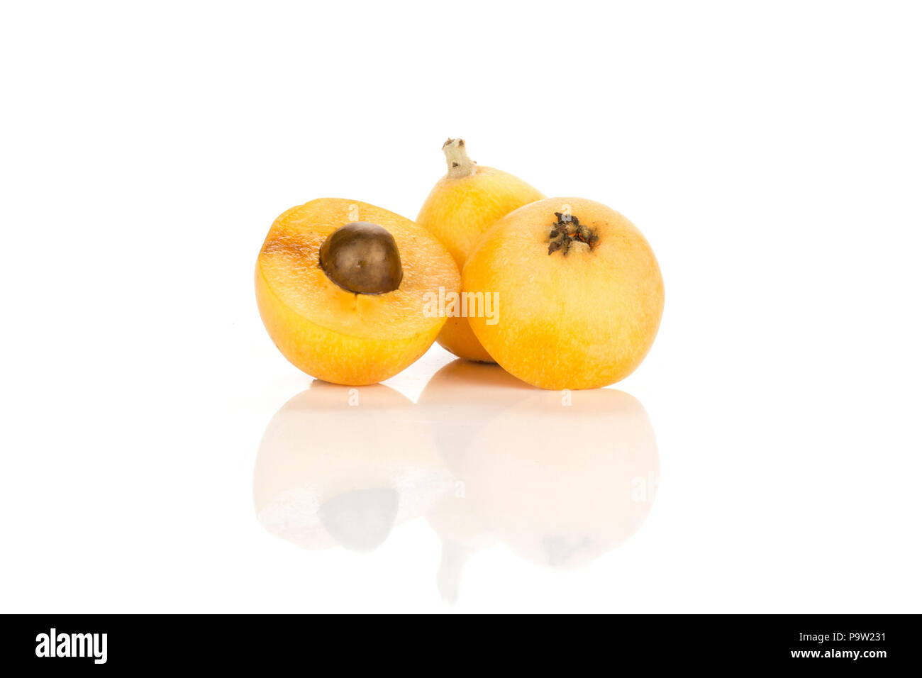 Fresh orange Japanese loquat set two whole and one half with a seed ...