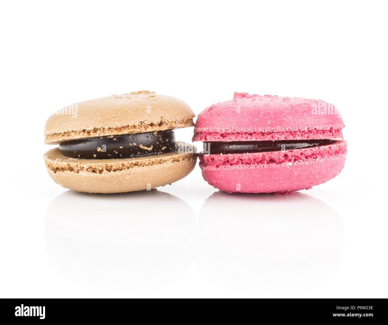 Two French macarons (chocolate and pink raspberry) isolated on white ...