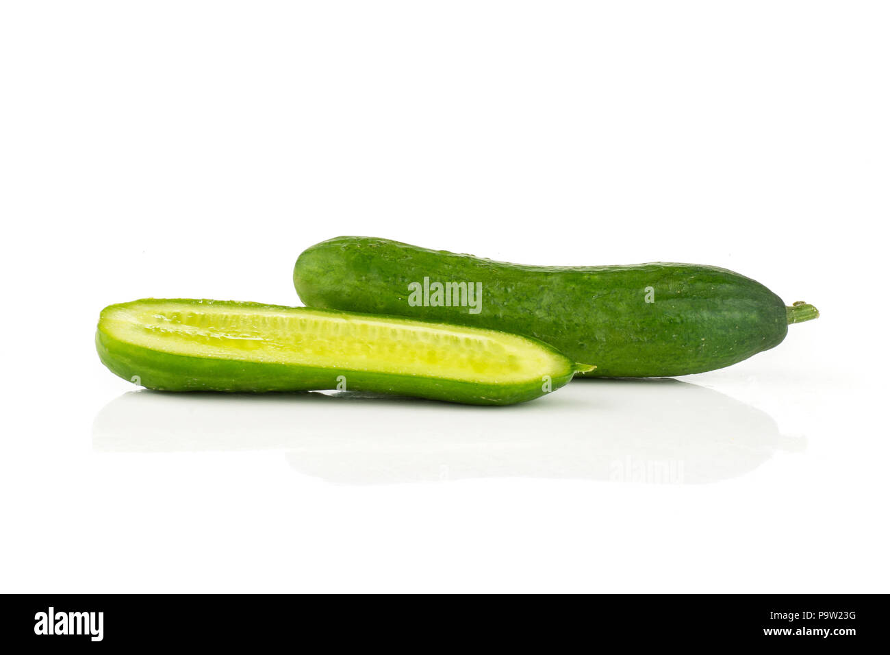 One fresh green mini cucumber and section half isolated on white ...