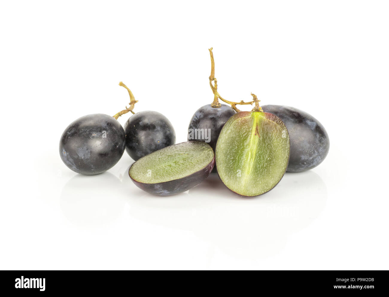 Black grapes (autumn royal variety) four berries and two sliced halves ...
