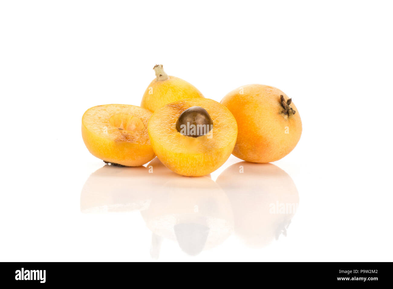 Two fresh orange Japanese loquat and two halves isolated on white ...