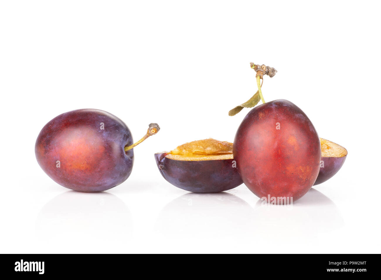 Group of two whole two halves of fresh violet-blue plum vibrant moyer ...