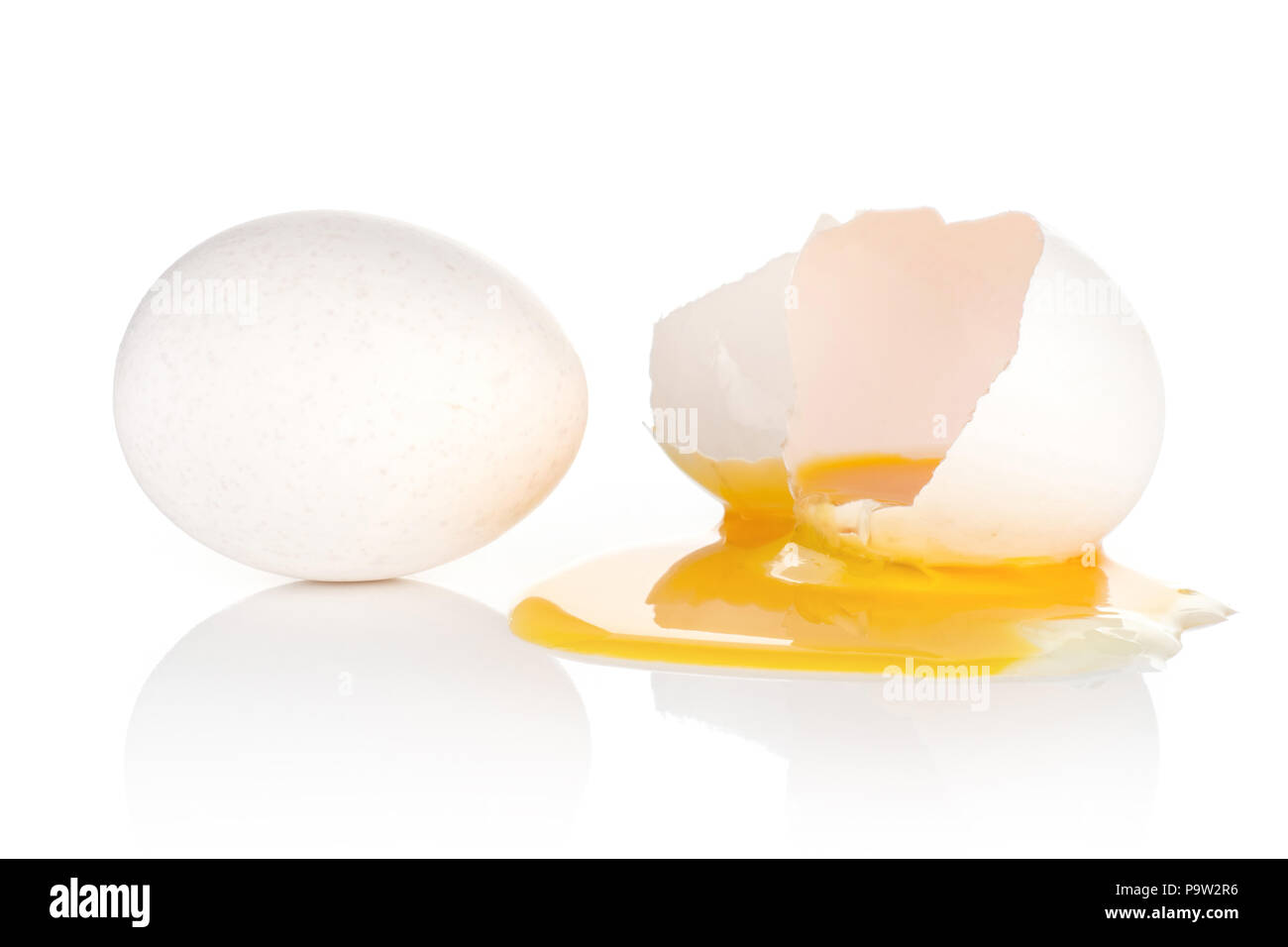 One white chicken egg and cracked eggshell pieces with dripping out yolk isolated on white ...