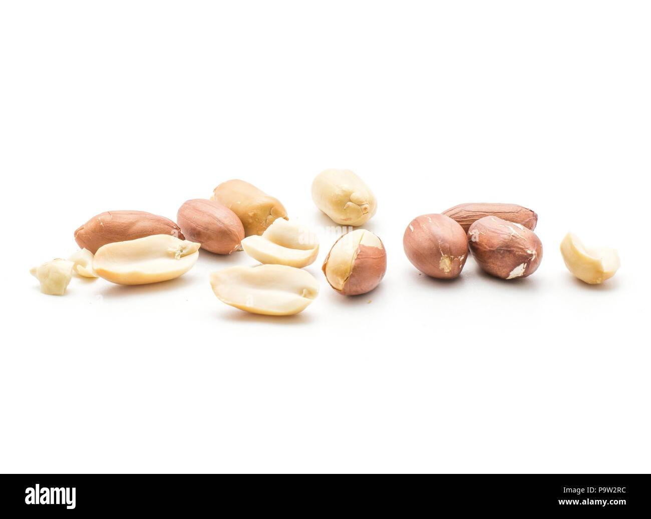 Shelled peanuts stack (some in husk, without and raw halves) isolated ...