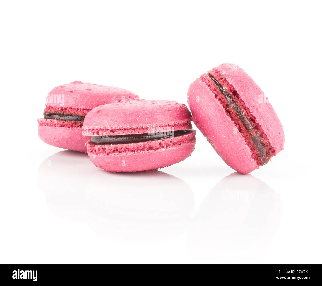 Three pink French macarons with raspberry inside isolated on white ...