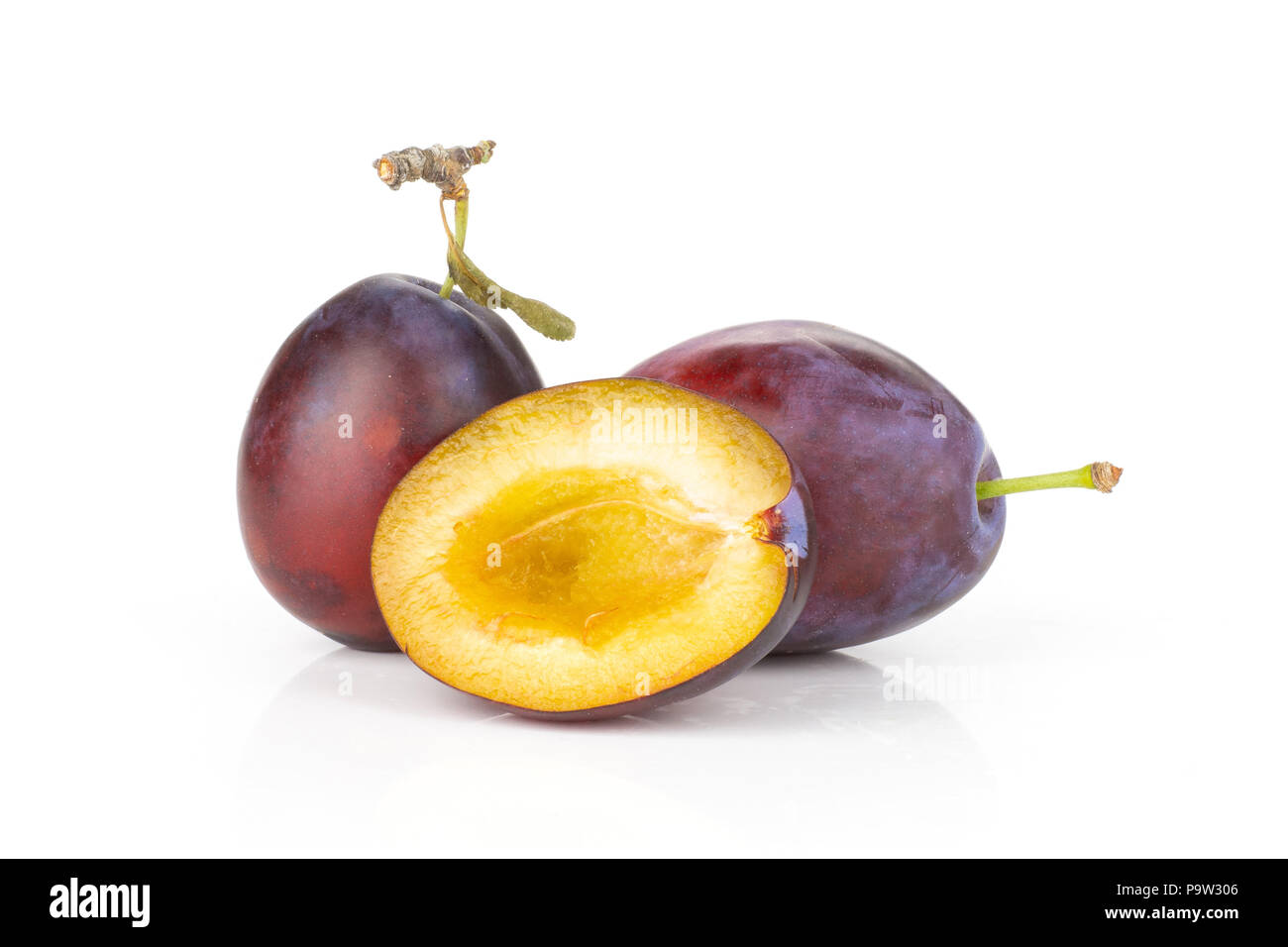 Group of two whole one half of fresh violet-blue plum vibrant moyer ...