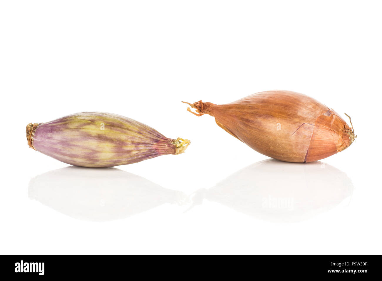 Two shallots isolated on white background comparing peeled and in a ...