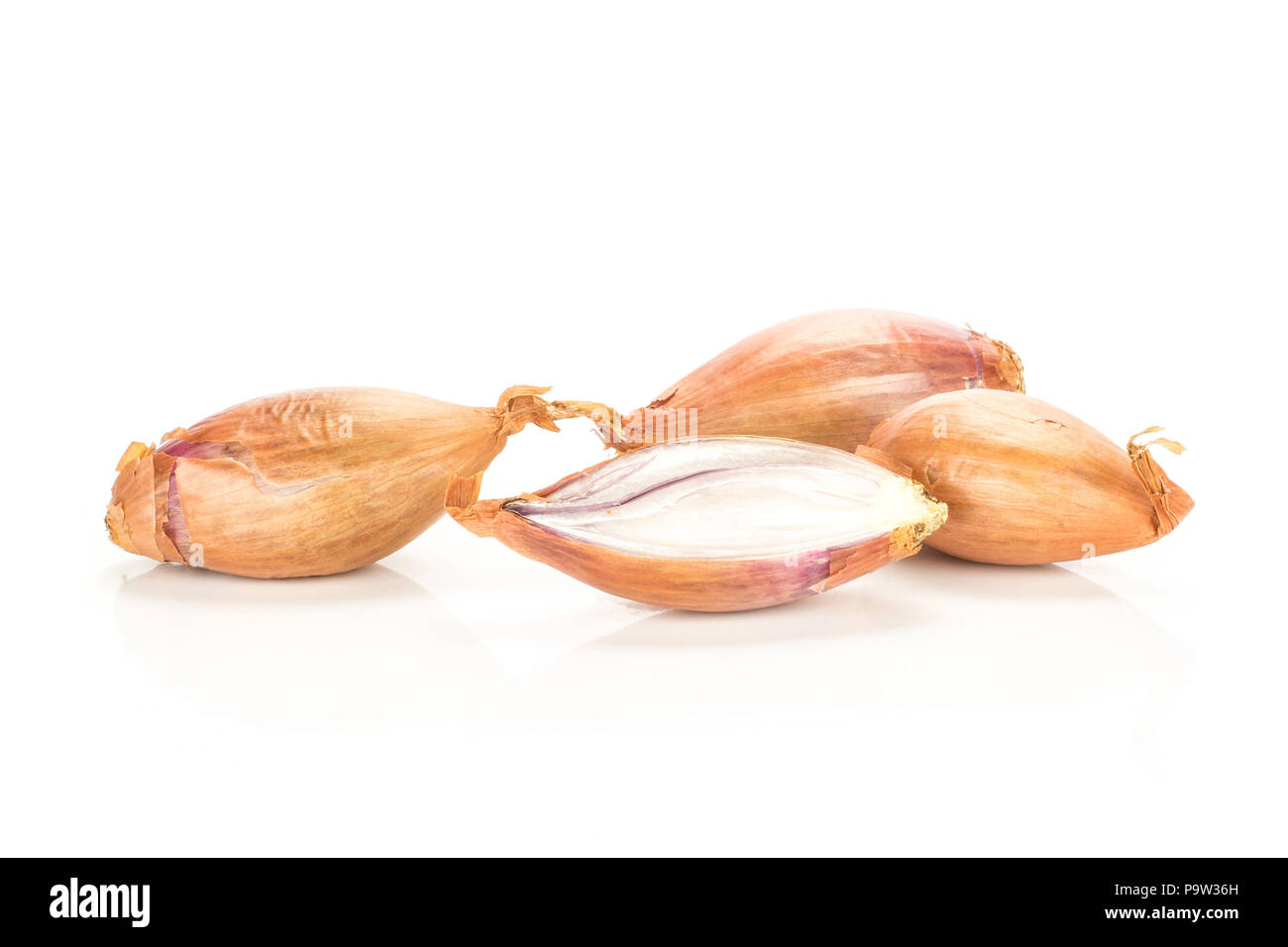 Three unpeeled shallots with one section half isolated on white ...