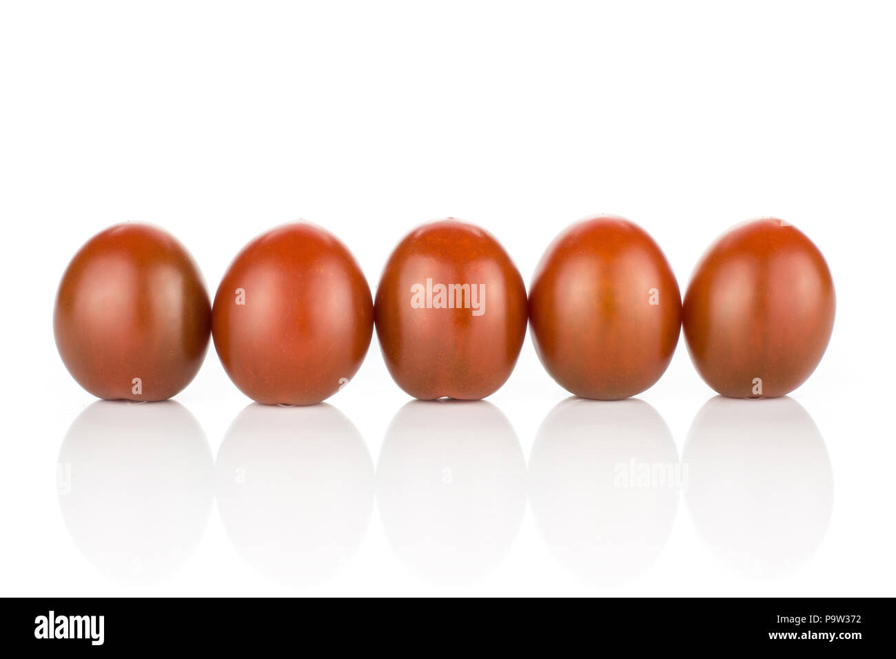 Five black red grape cherry tomatoes in row isolated on white ...