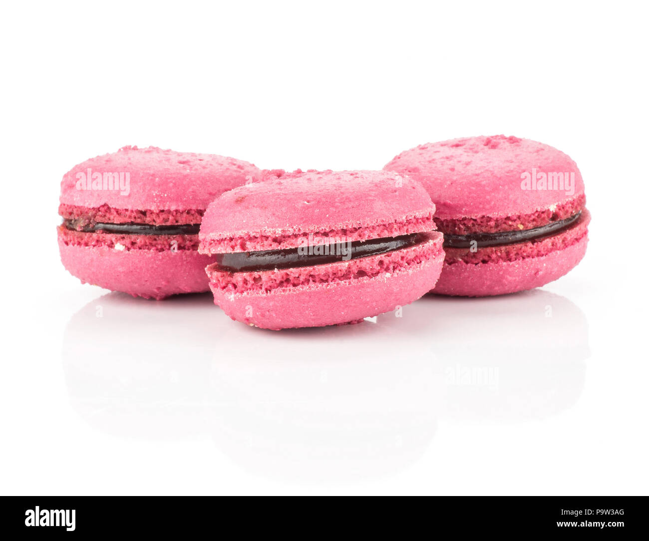 Pink French macarons three with raspberry jam isolated on white ...