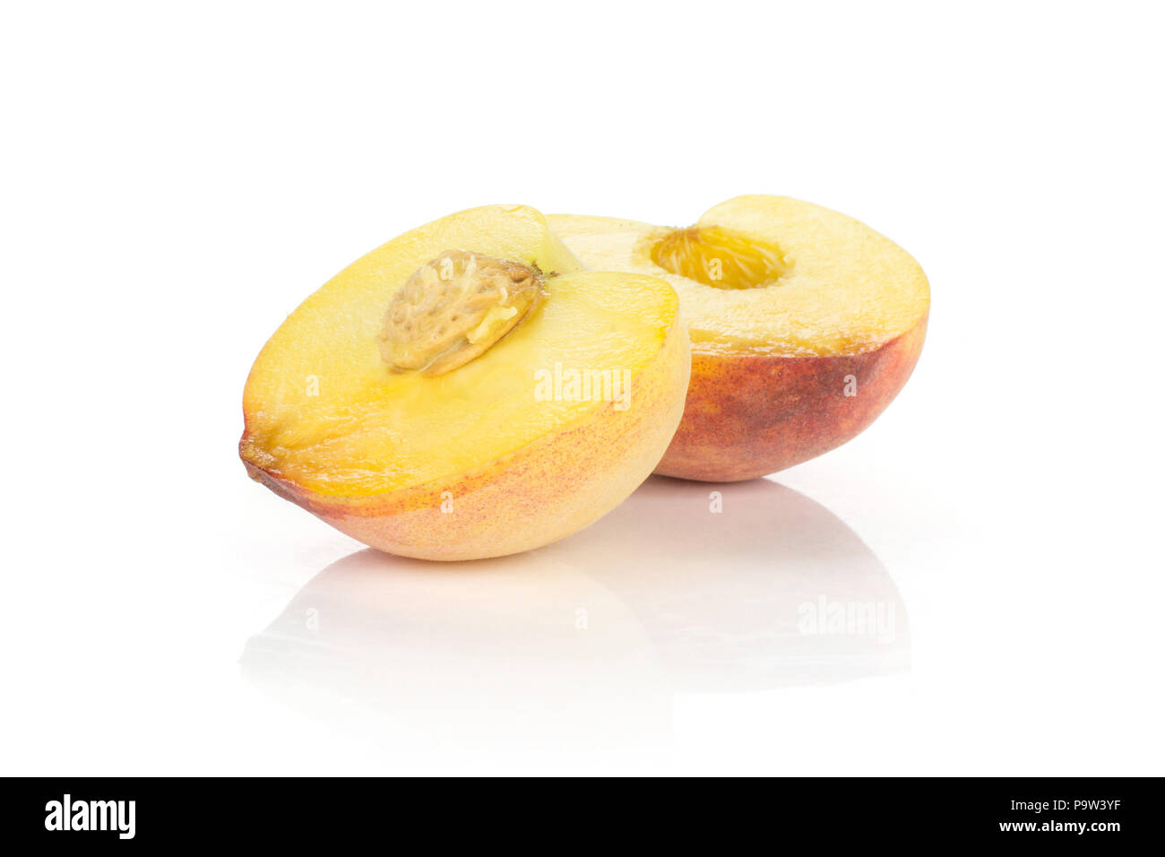One yellow peach cut in two halves isolated on white background Stock ...