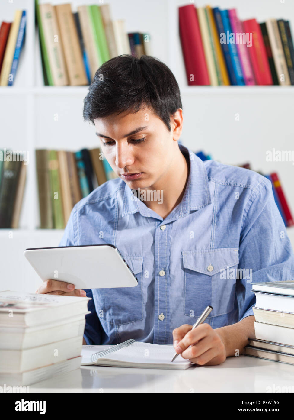 Student learning in library, using digital tablet Stock Photo - Alamy