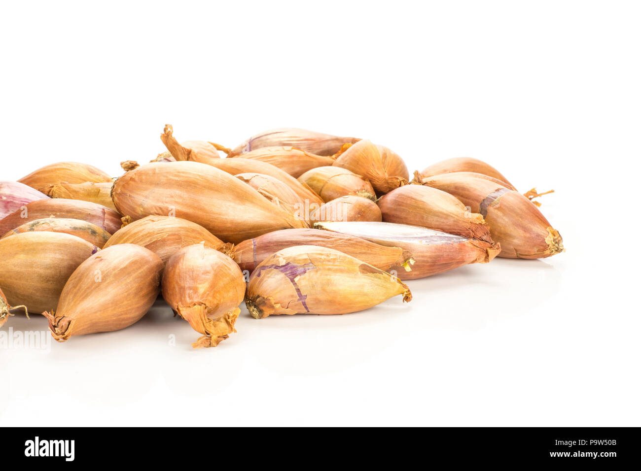 Golden shallots heap isolated on white background Stock Photo - Alamy