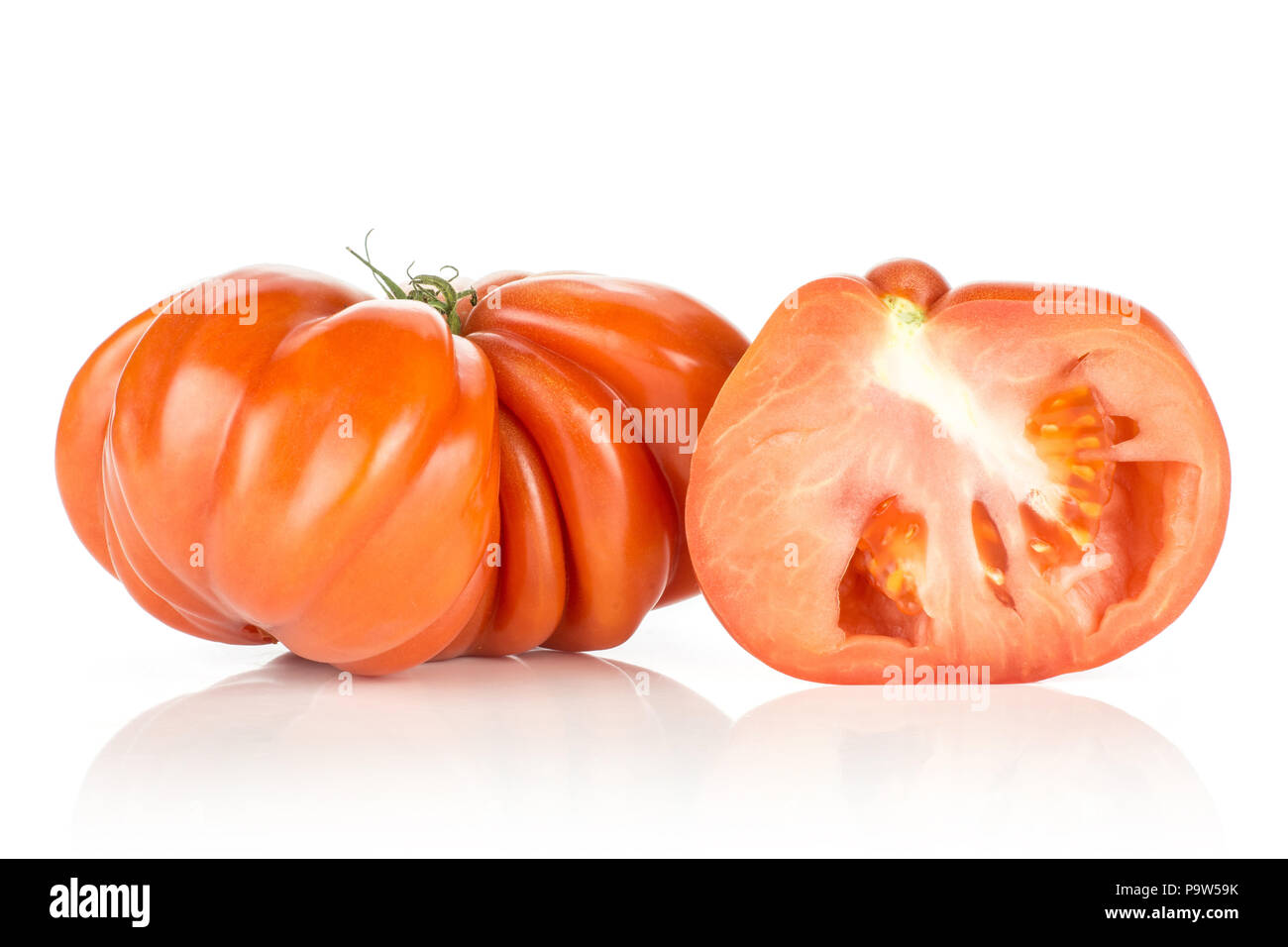 One beef tomato with sliced half isolated on white background big ripe ...