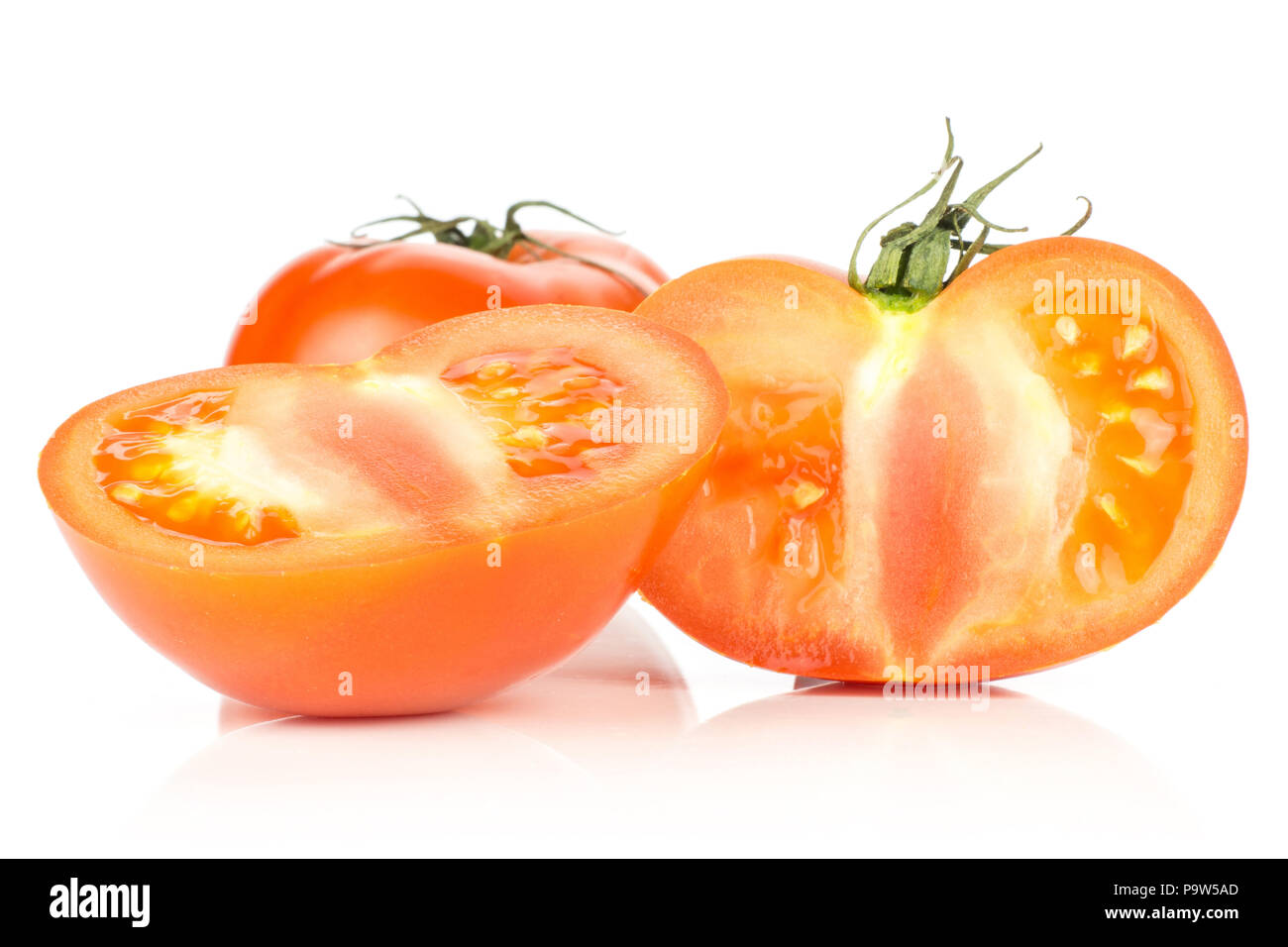 Red tomato cut in two section halves and one whole isolated on white ...