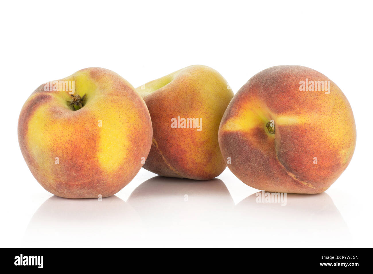 Three ripe yellow peaches isolated on white background Stock Photo - Alamy