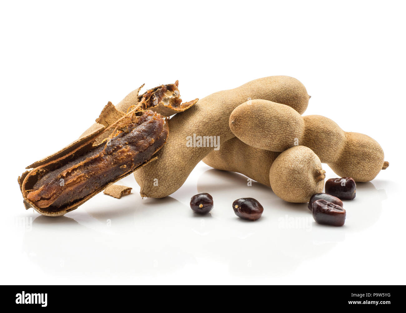Three tamarind in a brittle shell with flat glossy seeds and one open ...