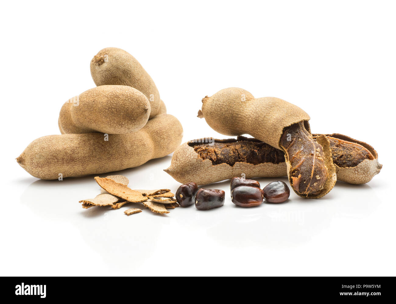 Five tamarind two open with glossy seeds and jelly brown flesh isolated ...