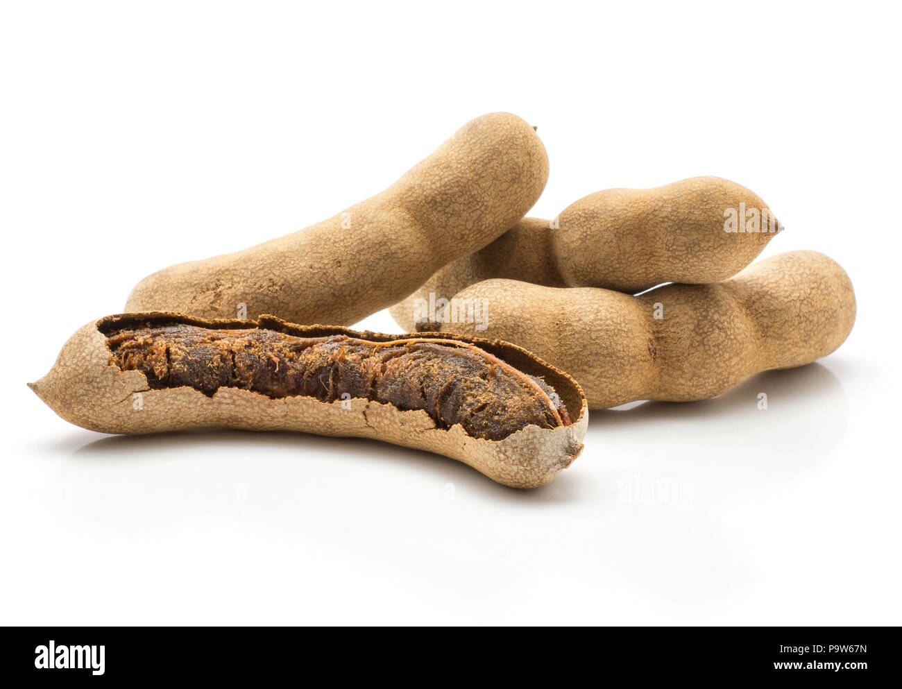 Three tamarind one broken with open brown flesh isolated on white ...