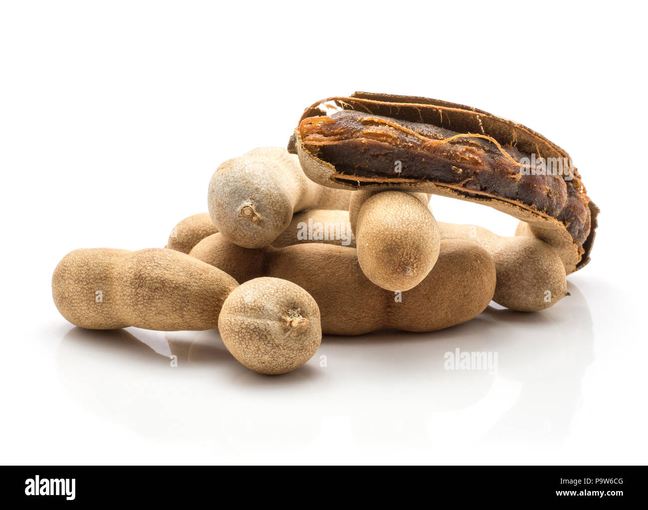 Tamarind in a brittle shell and one open with brown jelly flesh ...