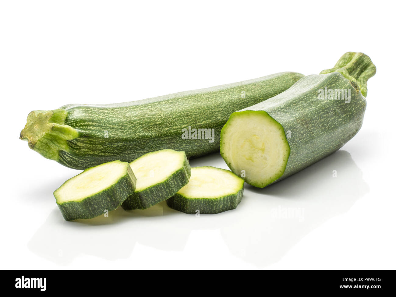 One green zucchini one half three round slices isolated on white ...
